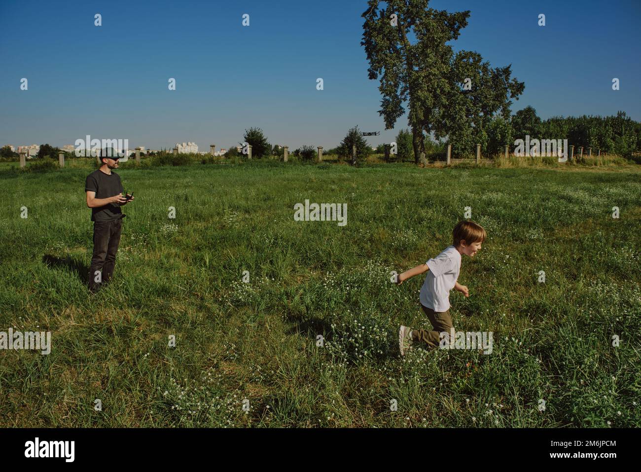 Father and son playing with flying drone, family Stock Photo - Alamy