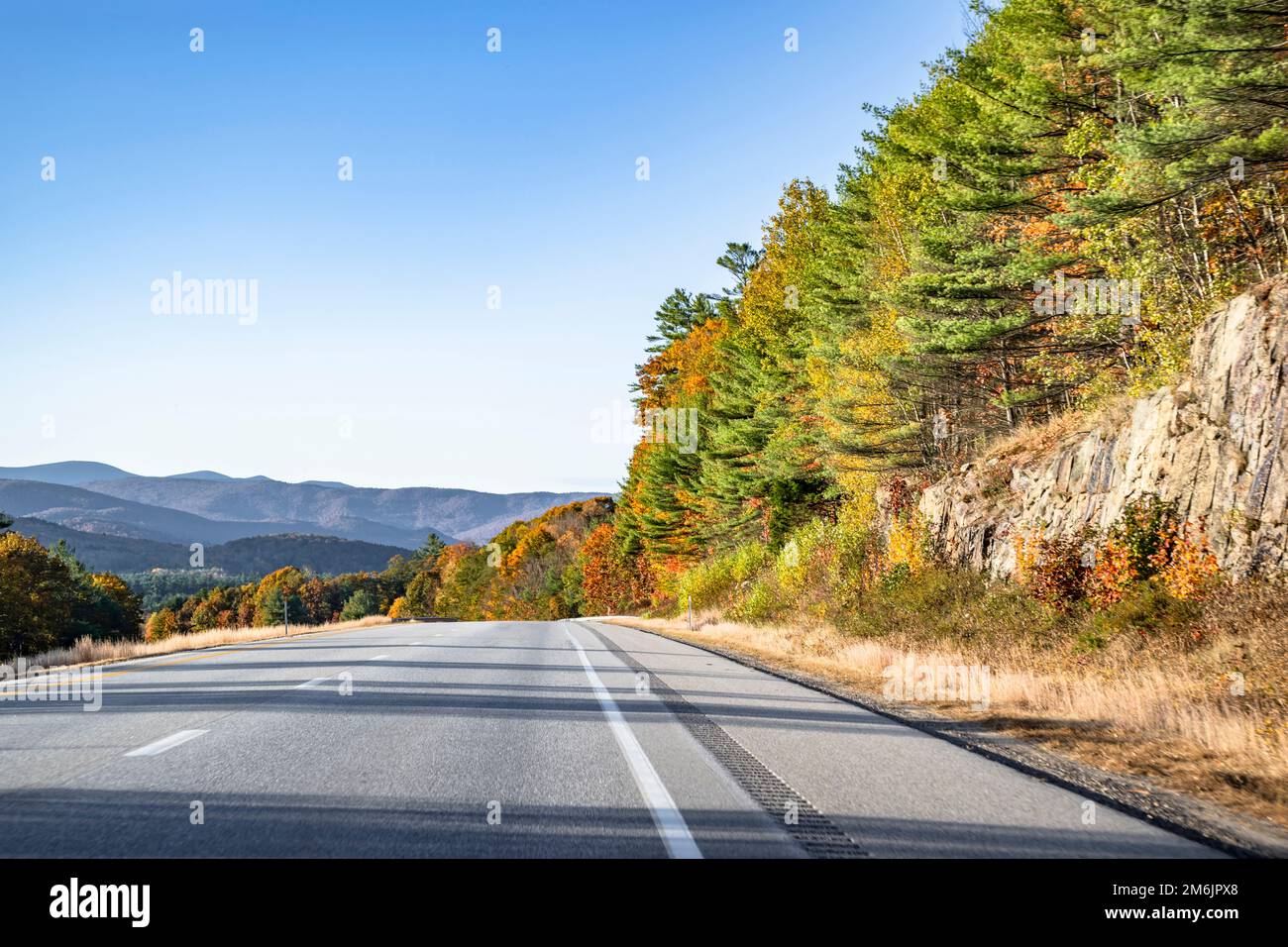 Scenic autumn landscape with a disappearing at horizon winding highway ...