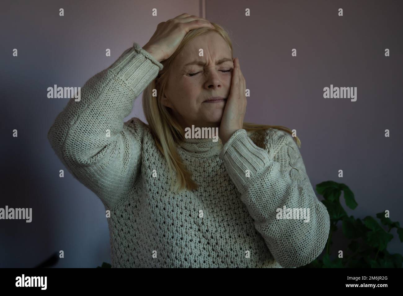 Office manager with a headache holding her head in pain Stock Photo - Alamy