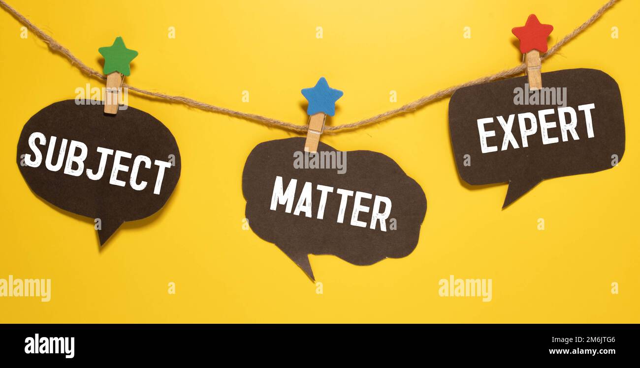 Subject Matter Expert text on notebook with keyboard , pen and alarm ...