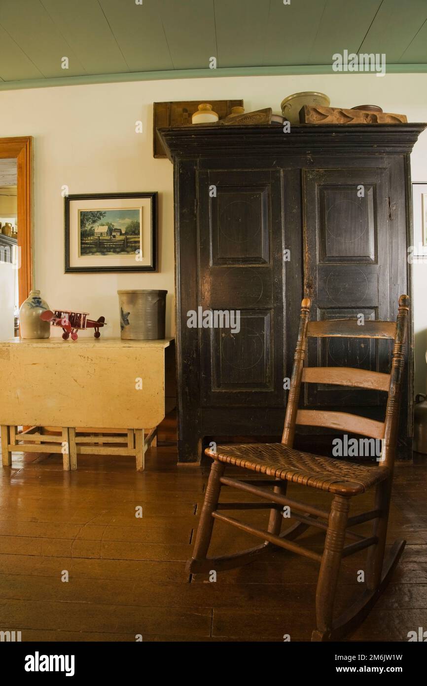Old wooden antique weaved seat rocking chair and armoire in dining room ...