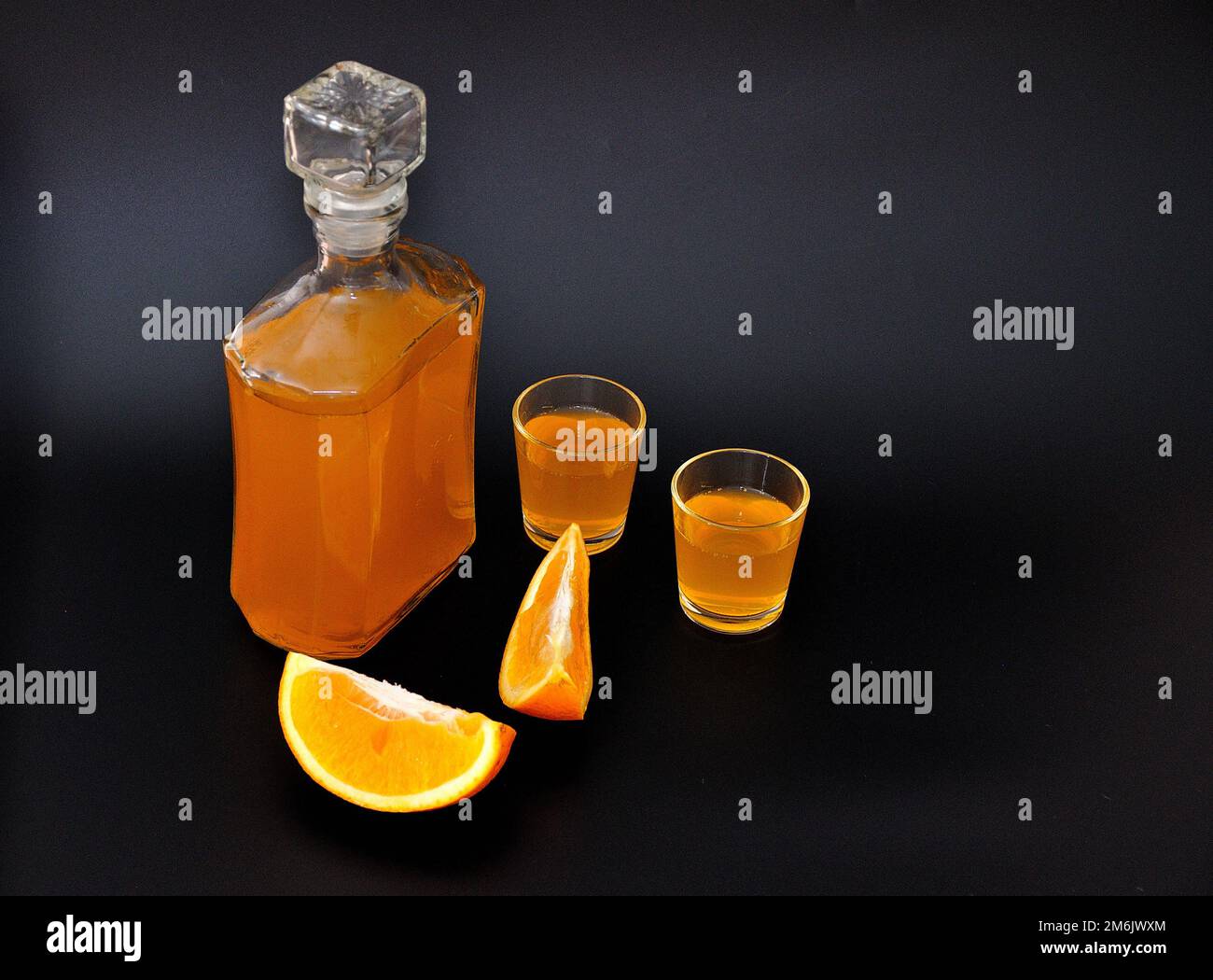 Orange liqueur, strong homemade alcohol with pieces of ripe citrus on a ...
