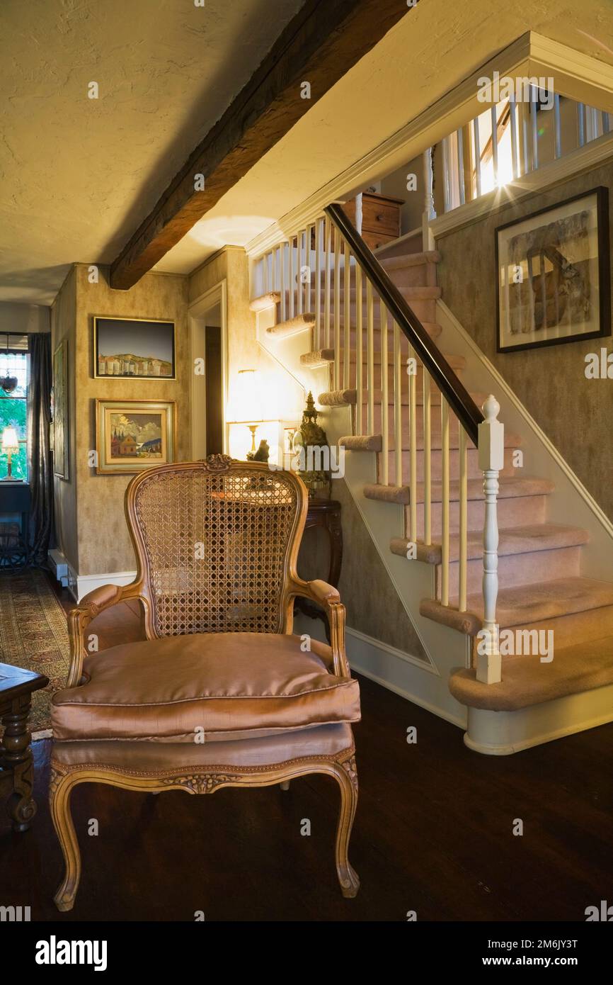 Antique wooden grid high back chair and carpeted staircase in living ...
