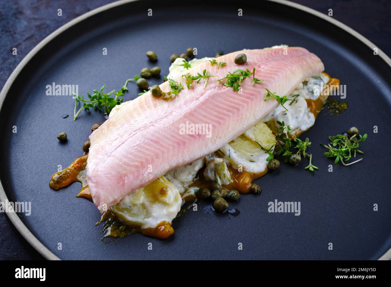 Modern style traditional smoked rainbow trout with boiled potato salad ...