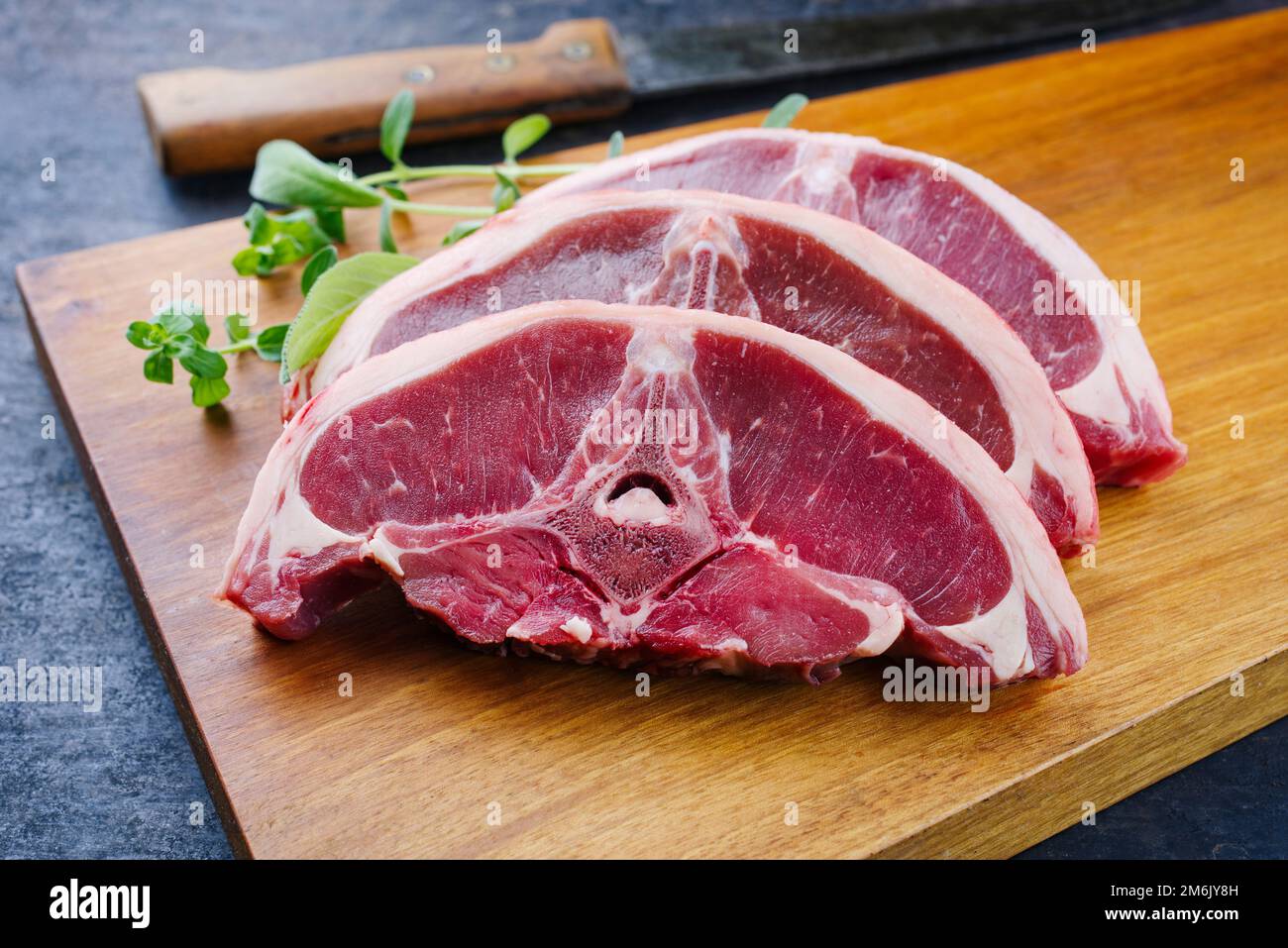 Raw lamb saddle back chop steak with herbs offered as close-up on a ...