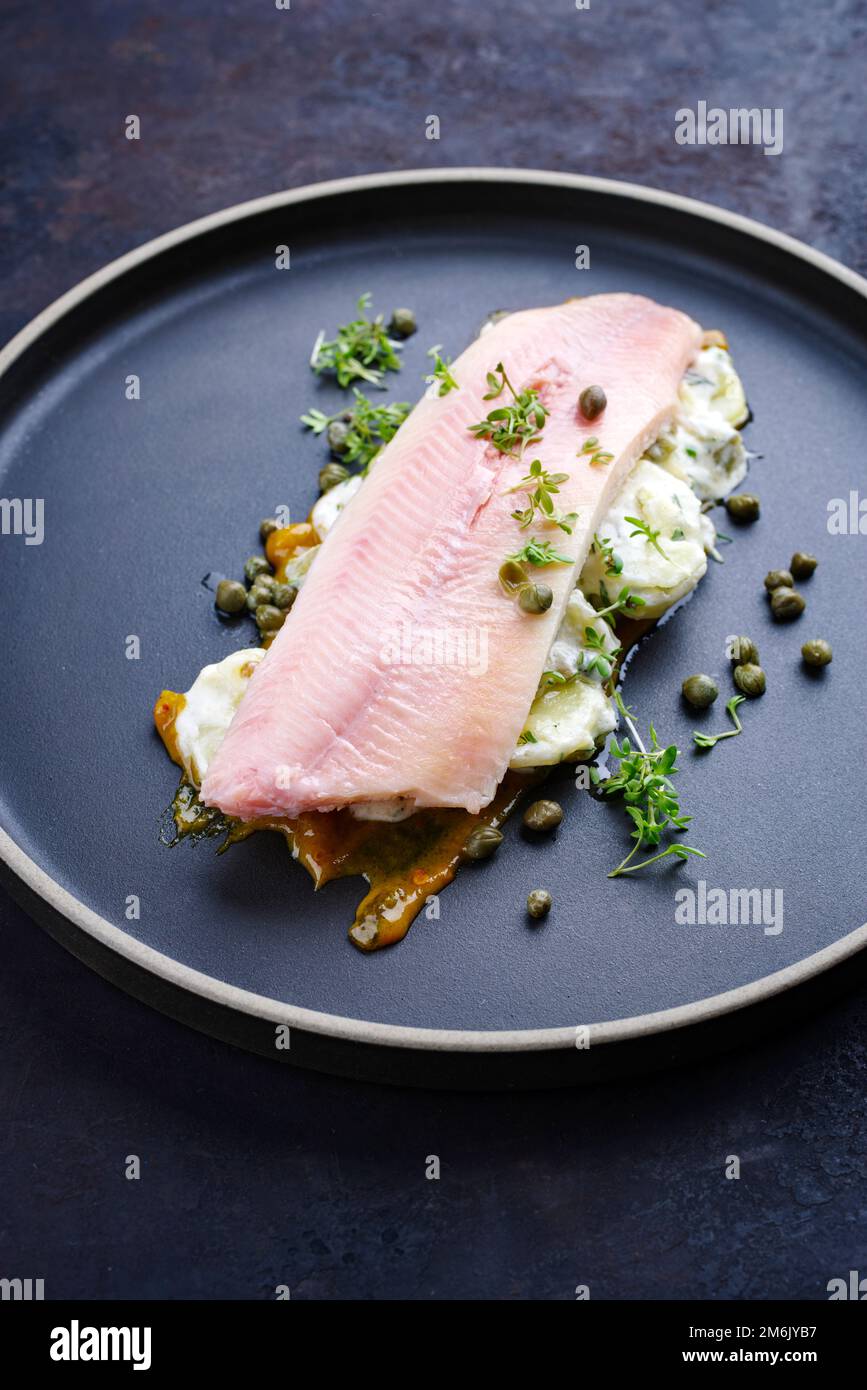 Modern style traditional smoked rainbow trout with boiled potato salad ...