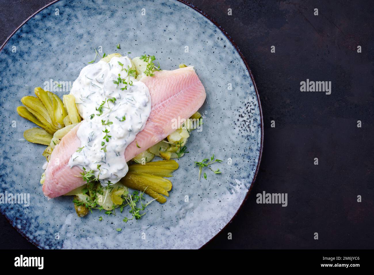 Modern style traditional smoked rainbow trout with boiled potato salad ...