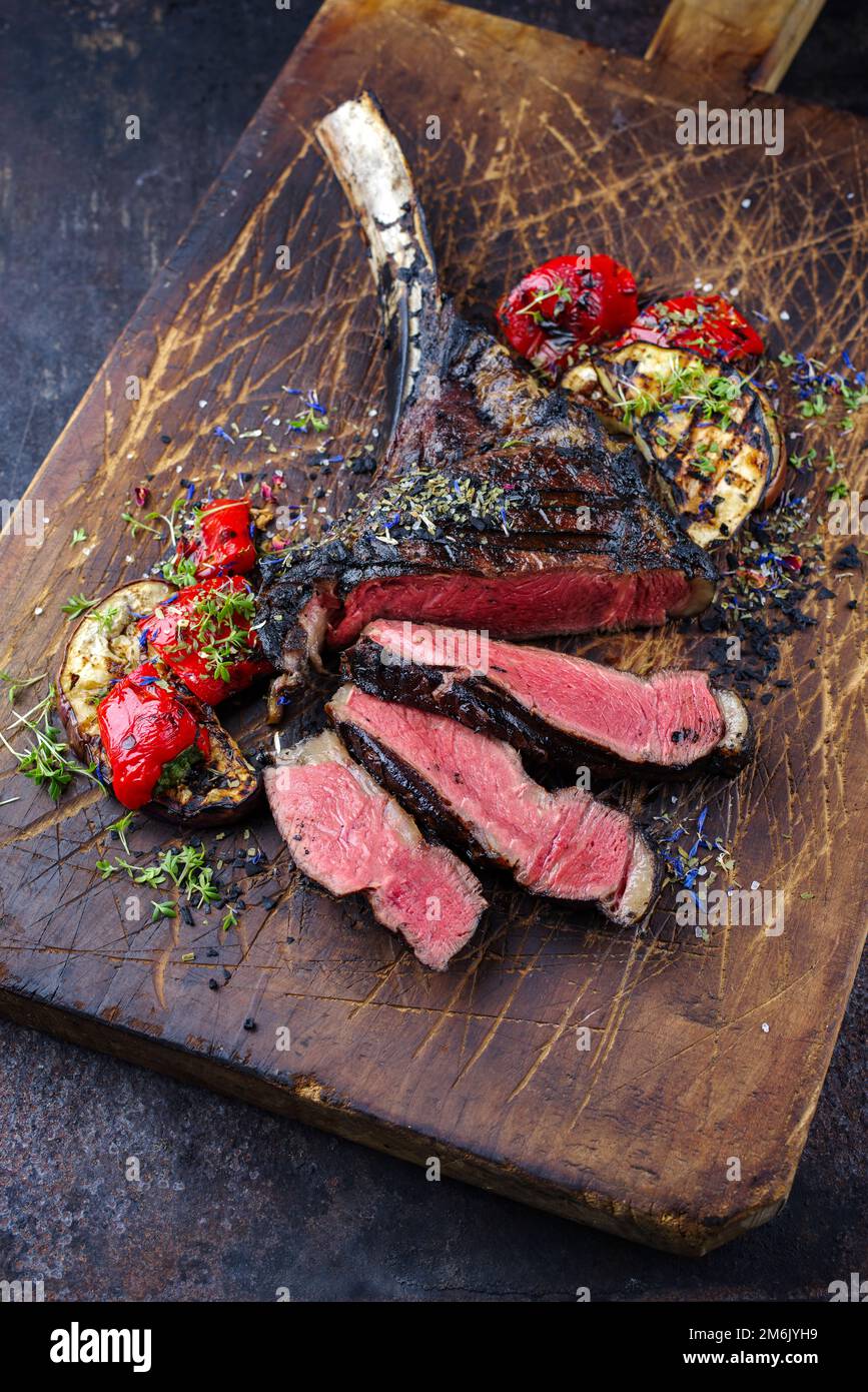 Modern style barbecue dry aged angus tomahawk steak with grilled ...