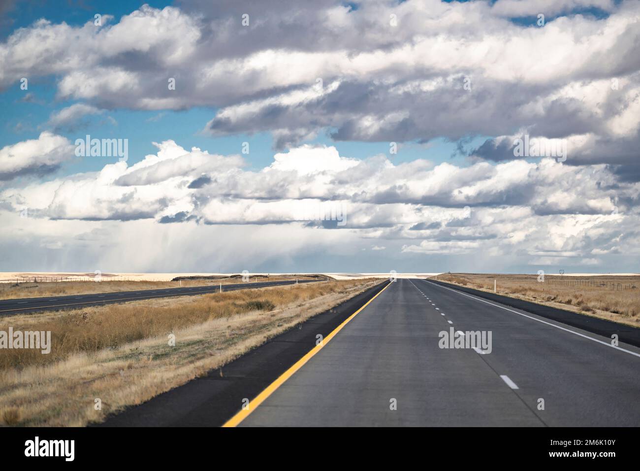 Scenic summer landscape with a disappearing at horizon straight highway ...