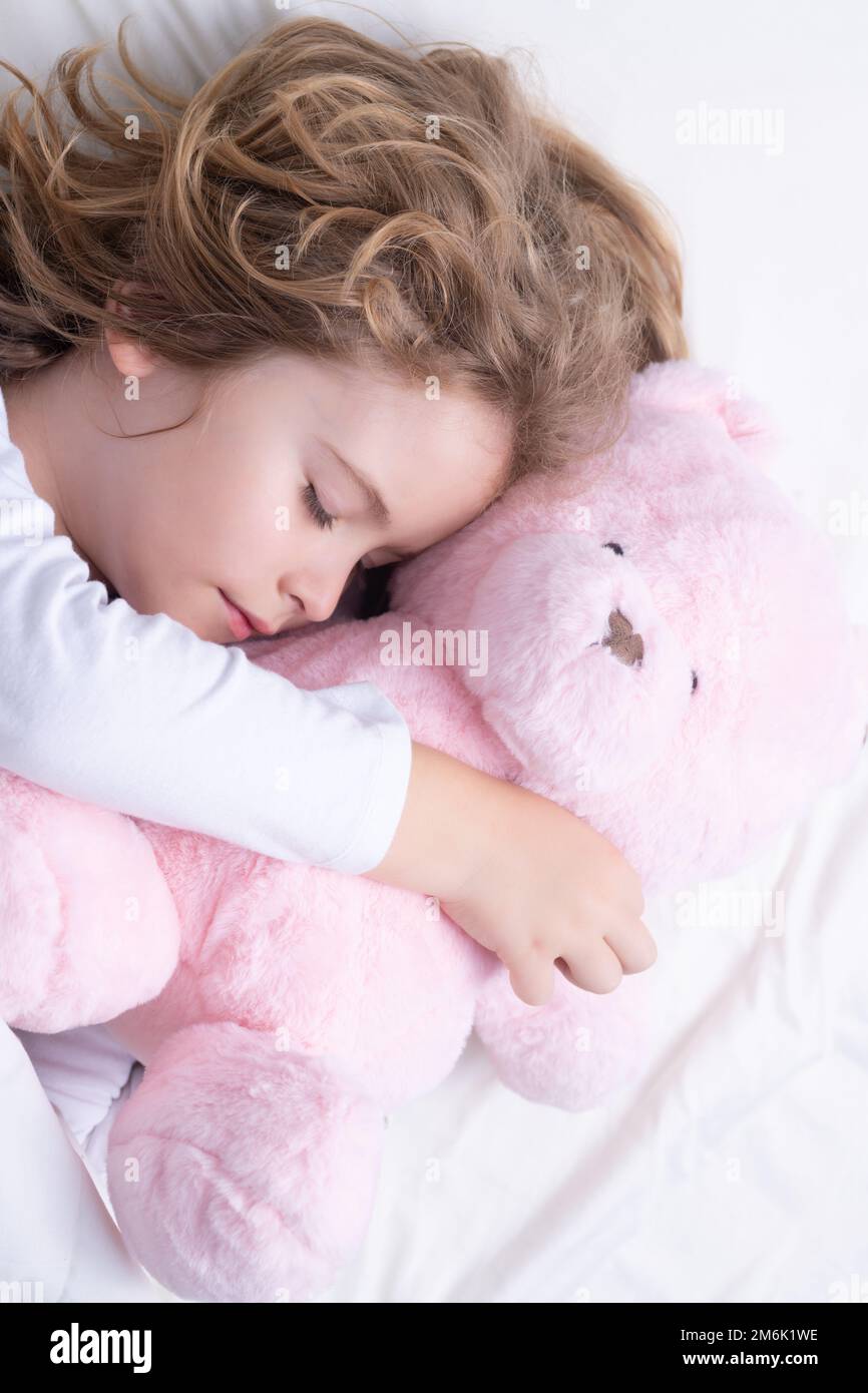 Morning sleep. Adorable kid sleeps with a toy teddy bear in bed ...