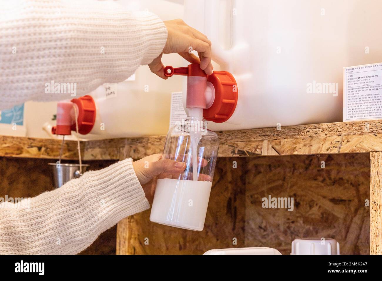 eco friendly habits hand gesture refilling detergent at zero waste shop ...