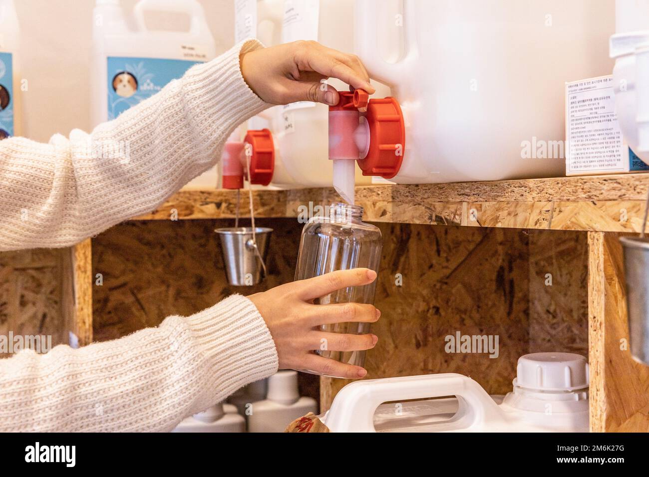 eco friendly habits hand gesture refilling detergent at zero waste shop ...