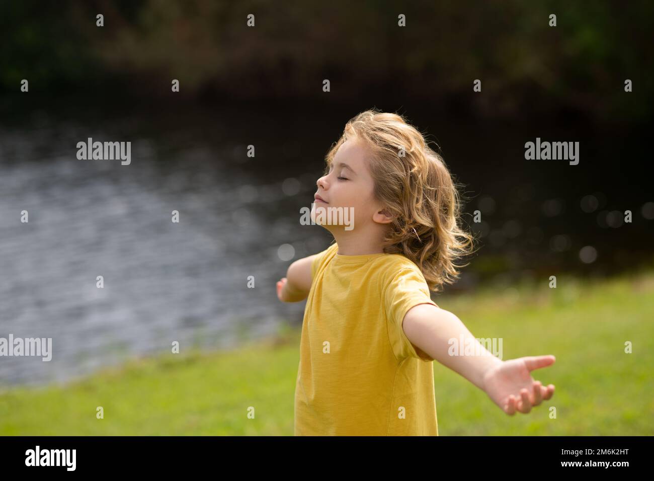 Peaceful kid with raised hands meditating, feeling calm. Kid practice ...