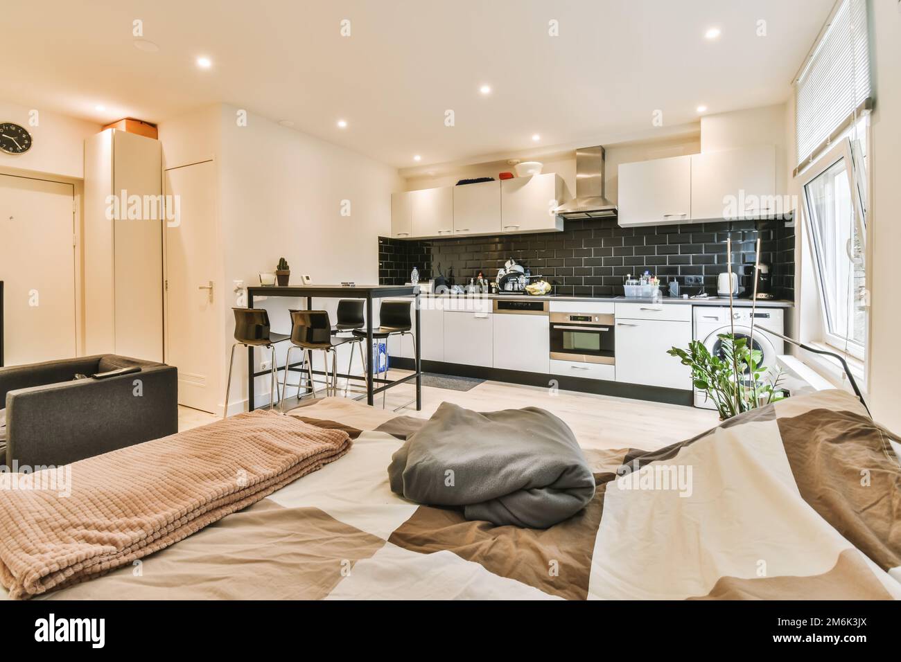 a living room with an open kitchen and dining area on the other side of ...