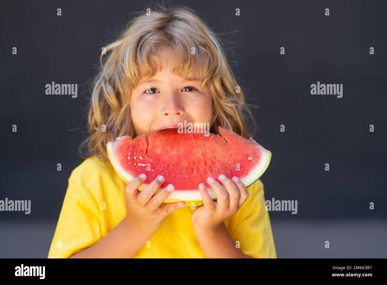 Kid face and watermelon, close up. Child boy eat watermelon. Kid is ...
