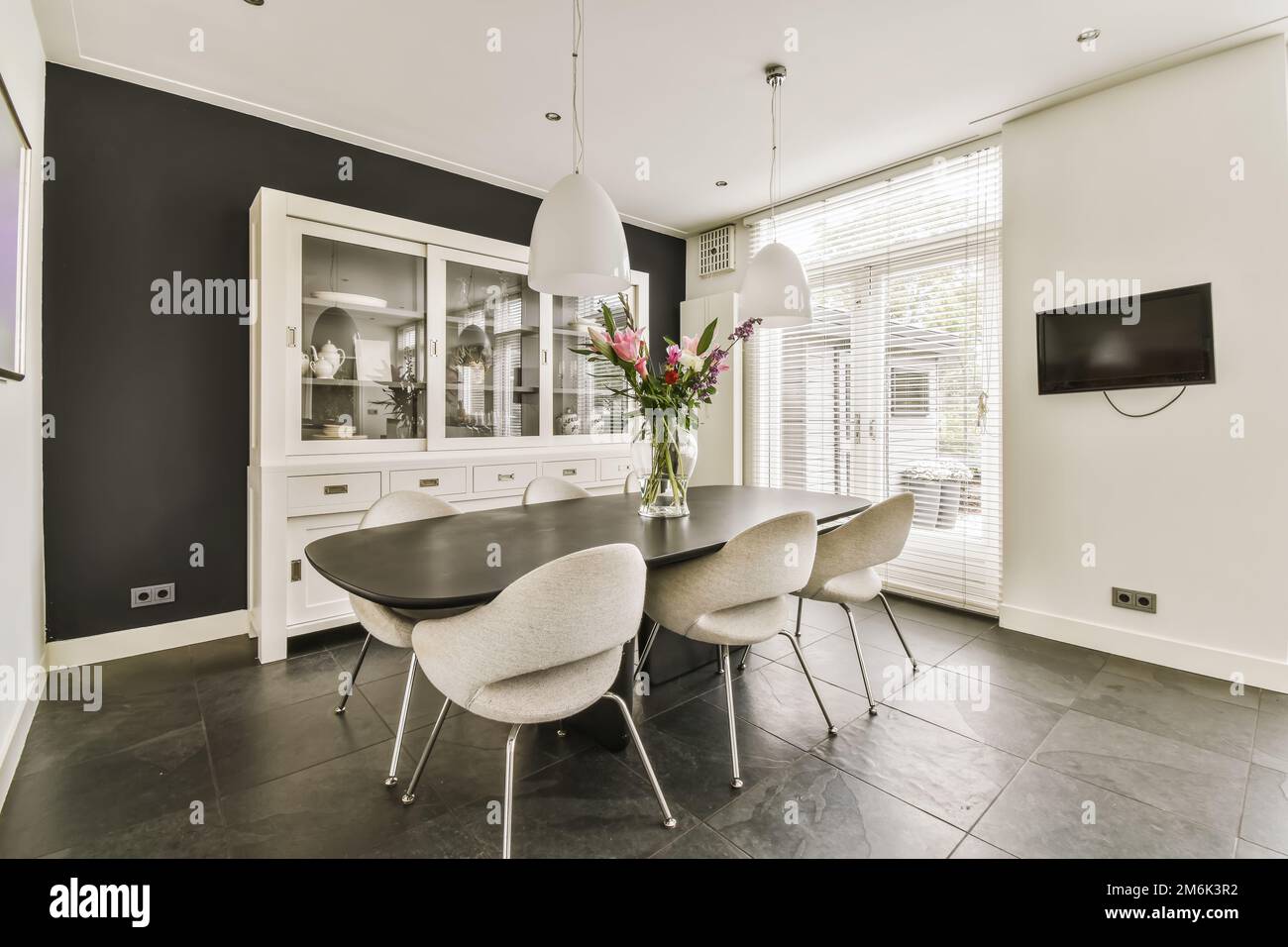 a modern dining room with black walls and white trim around the window ...