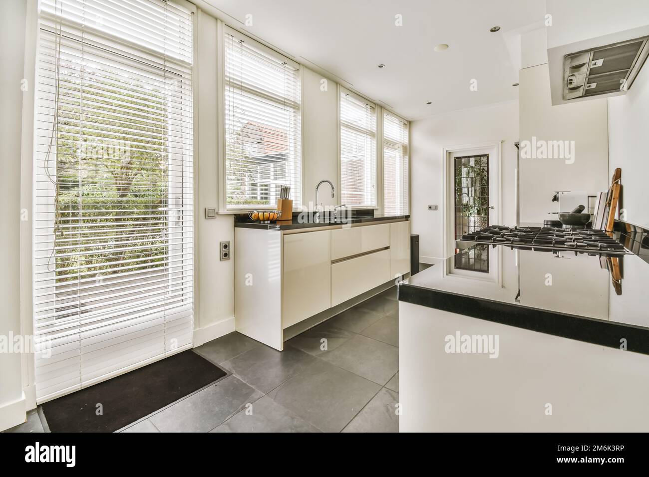 a modern kitchen with black counter tops and white shutters on the ...