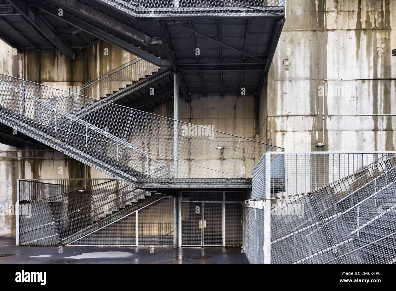 detail of a raw concrete building with industrial iron staircase and ...