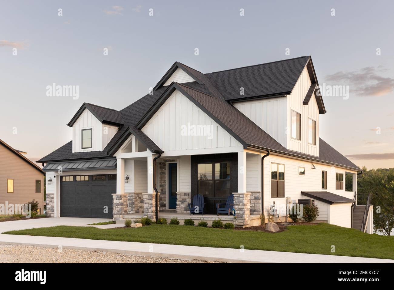 A black and white luxury home with a two car garage and black door ...