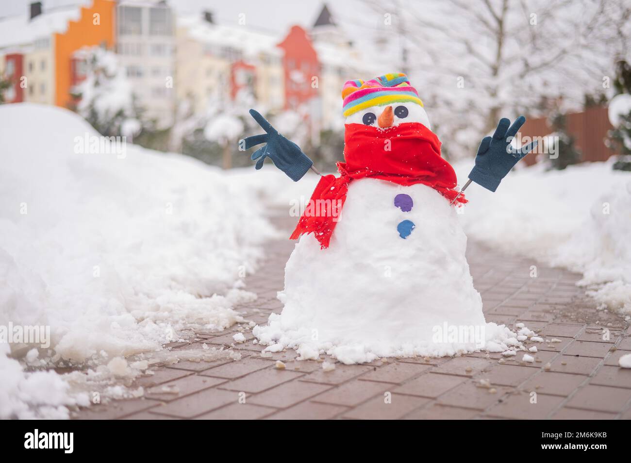 Snowman in a hat and gloves on the sidewalk from paving slabs Stock ...