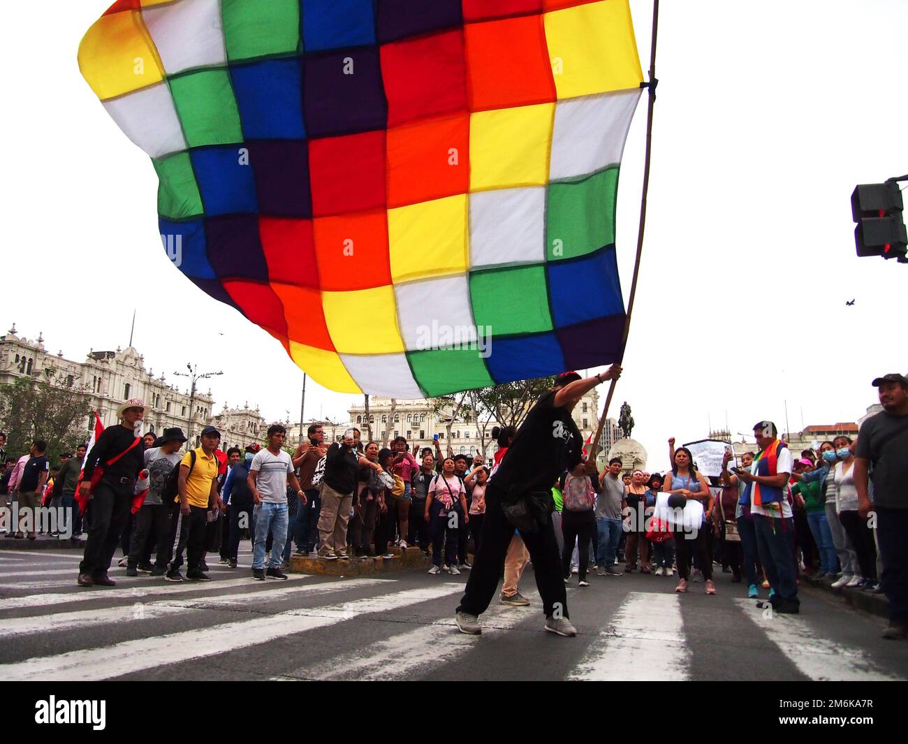 A man waving a "Wiphala", the flag of the Andean indigenous peoples ...