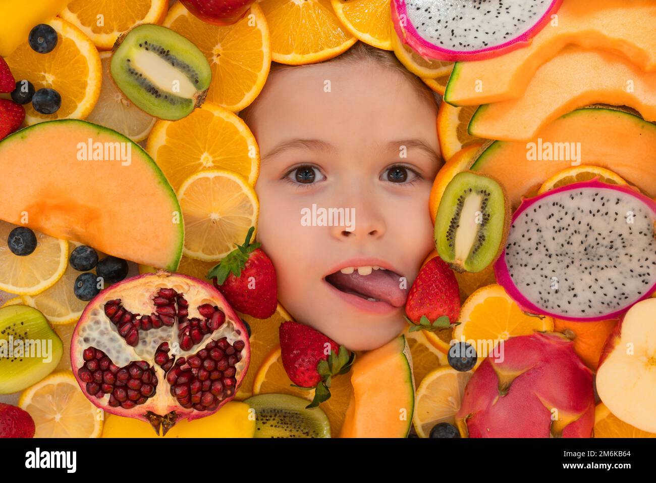 Kid lick strawberry. Funny child eats organic fruits. Healthy meal ...