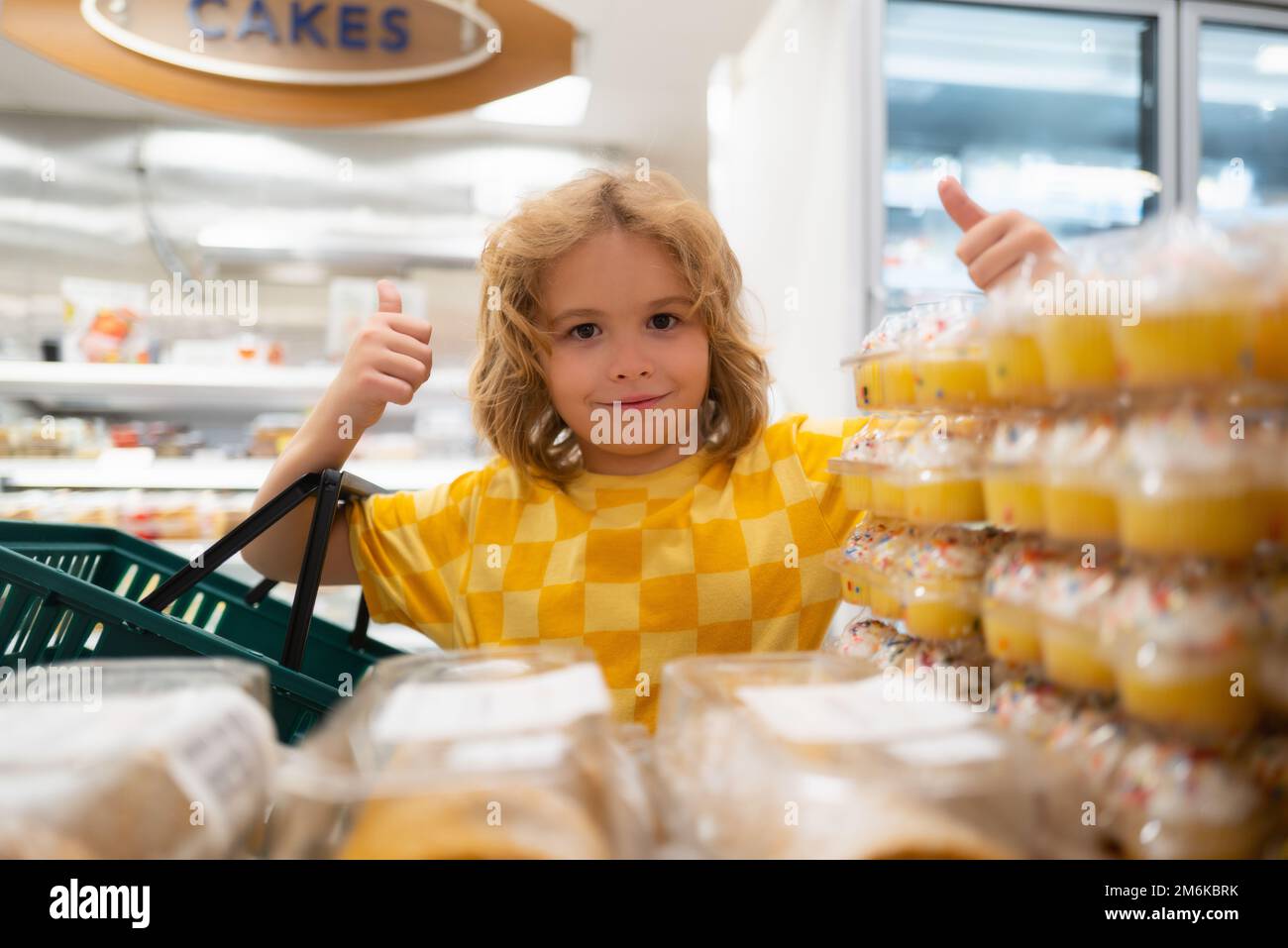 Kid choosing cakes, cupcake muffin. Shopping in supermarket. Kids ...