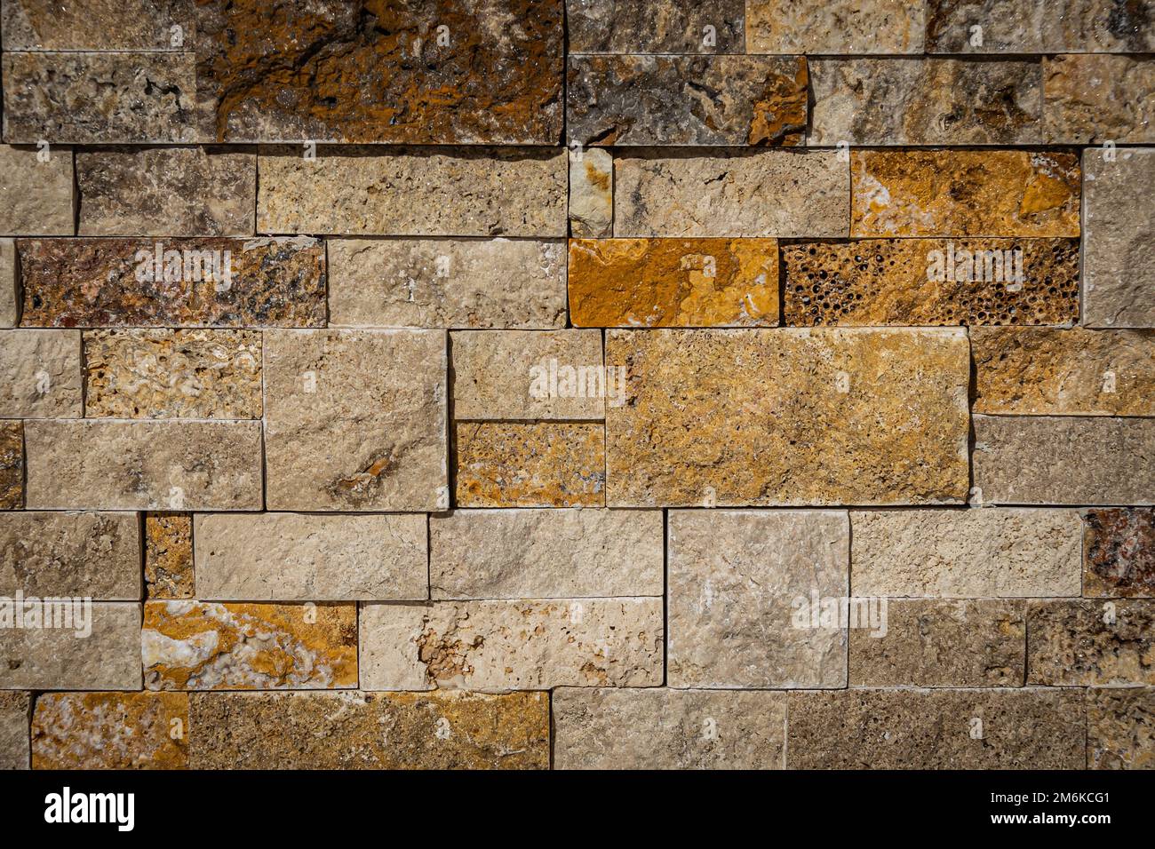 Close up of a granite stacked stone wall texture in beige and orange ...
