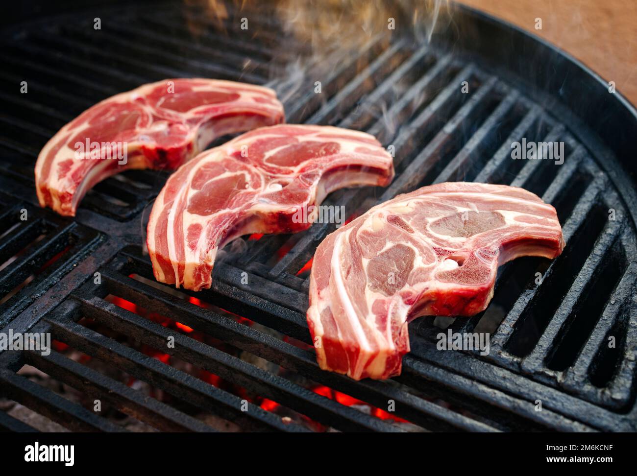 Raw lamb saddle back chop steak grilled as close-up on a charcoal grill ...
