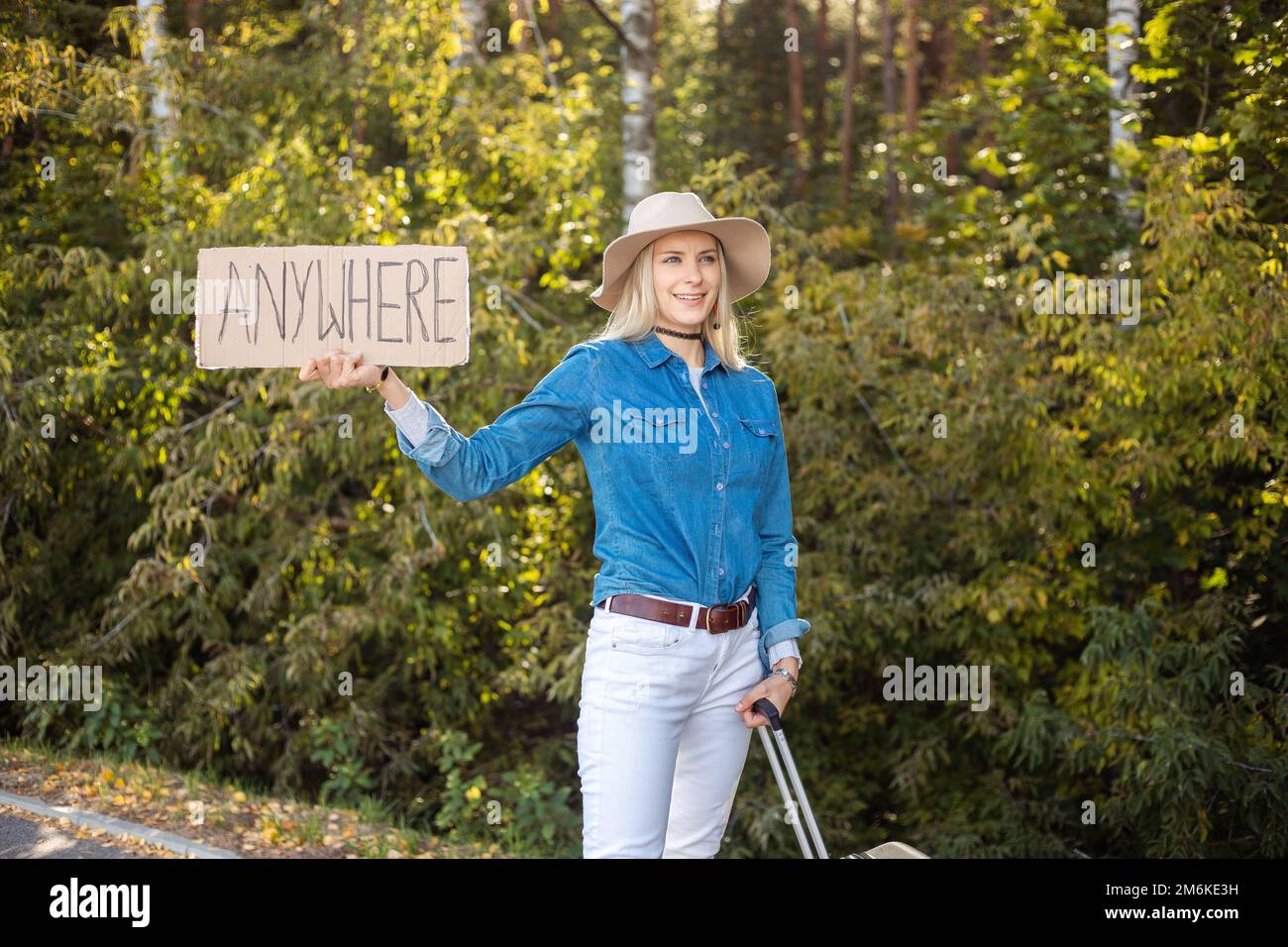 Portrait of young smiling blond woman raising cardboard with ...