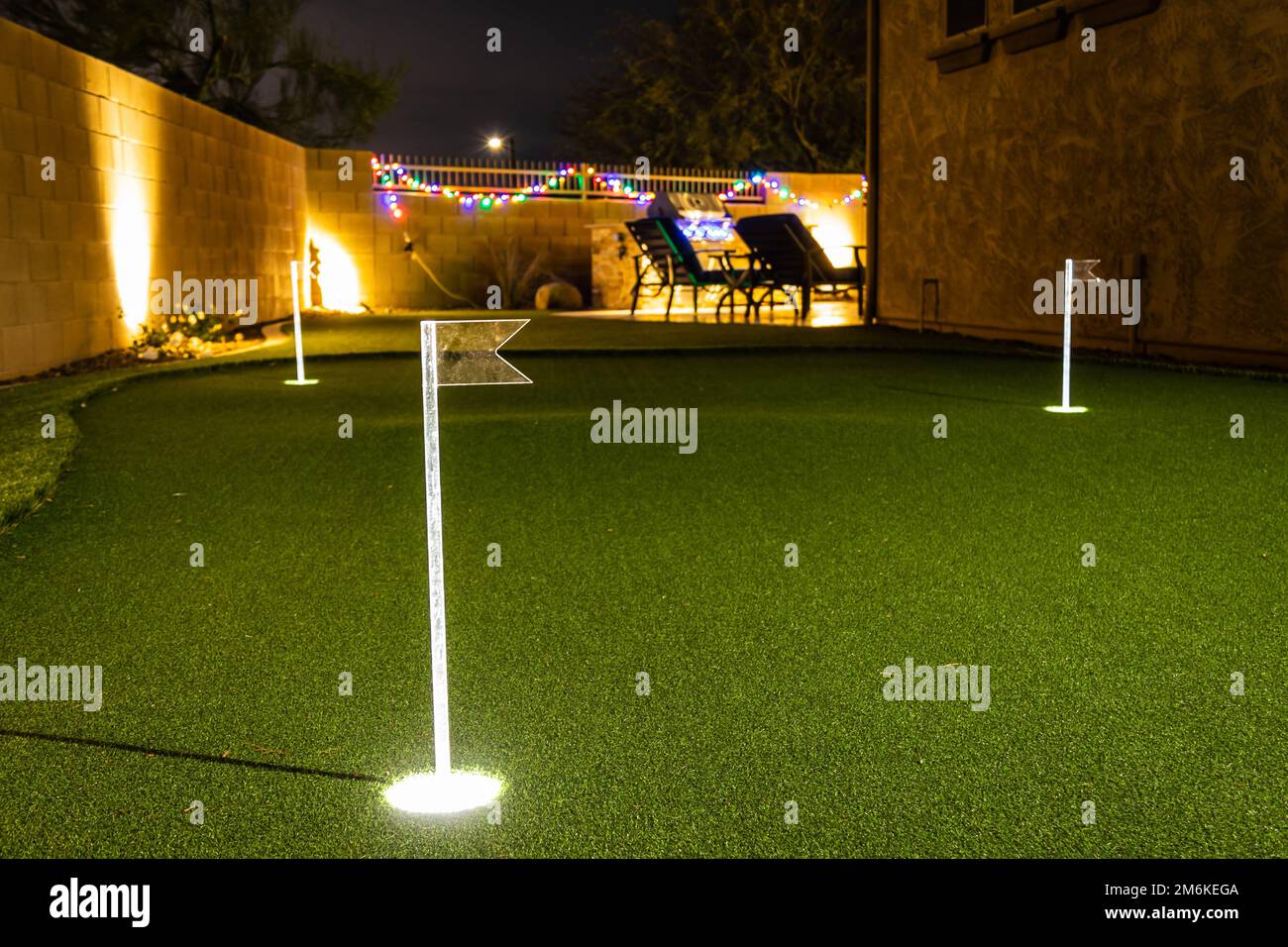 Nighttime image of a personal home putting green with illuminated holes ...