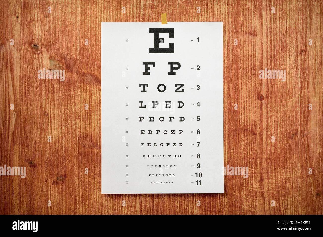 White optometry chart on the wooden wall Stock Photo - Alamy