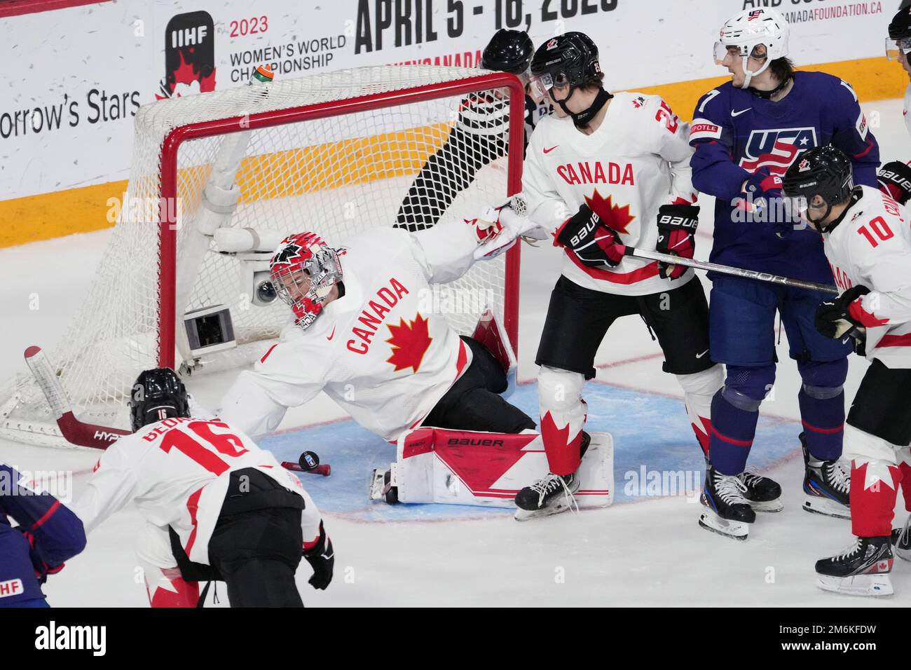 Canada goaltender Thomas Milic, centre, reaches back to make a stick ...