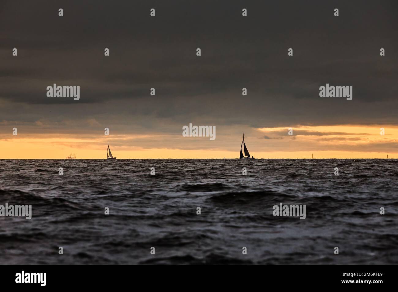 Sailboat in sea at stormy weather, stormy clouds sky orange sky, sail ...