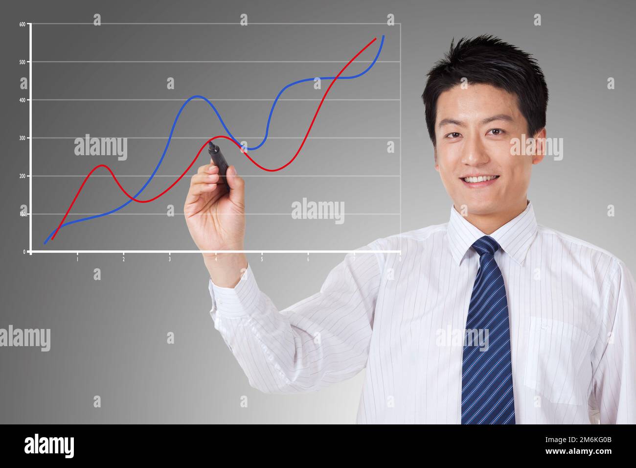 A young business man drawing curve chart Stock Photo - Alamy