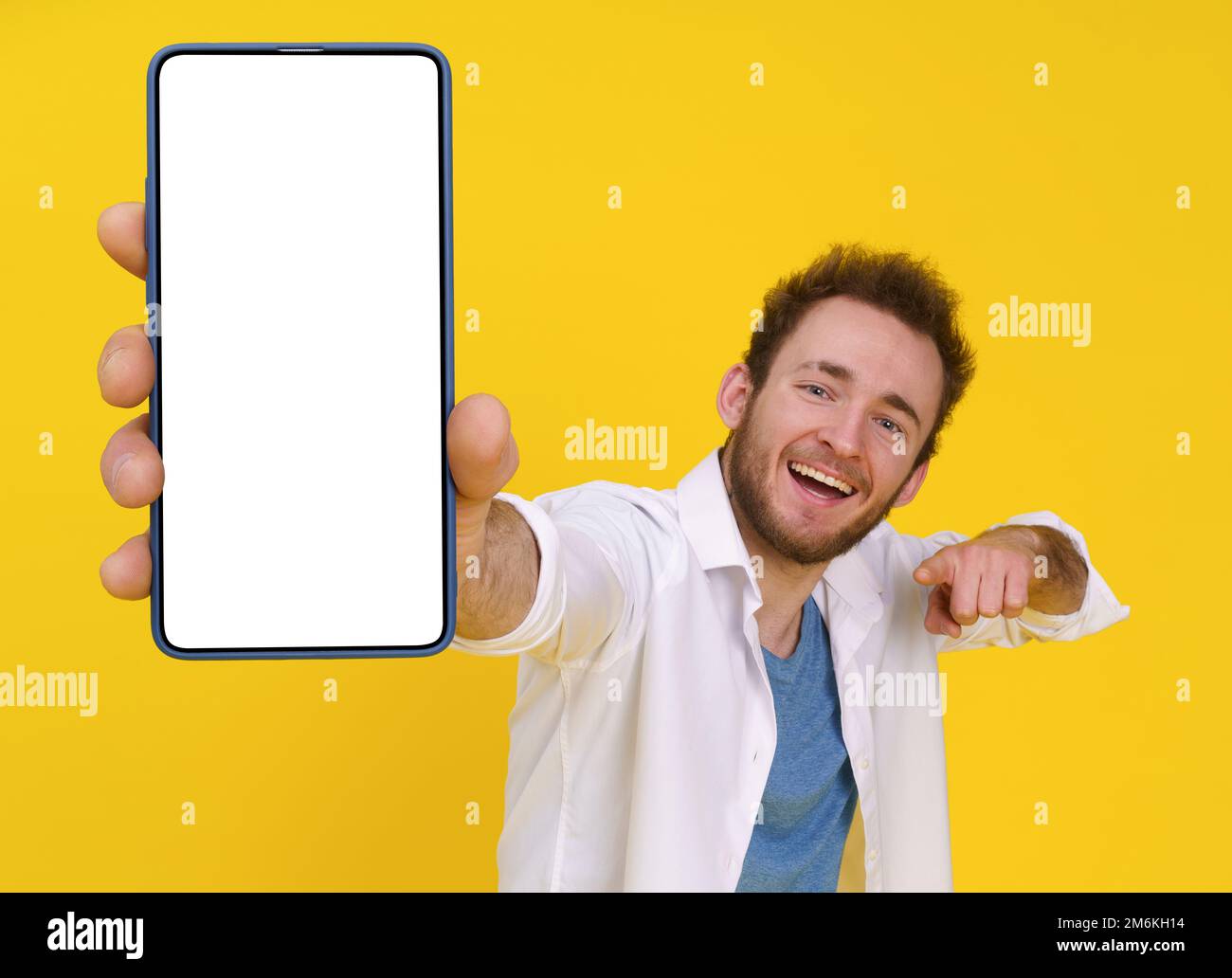 Happy young guy with smartphone in hand showing a black empty screen ...