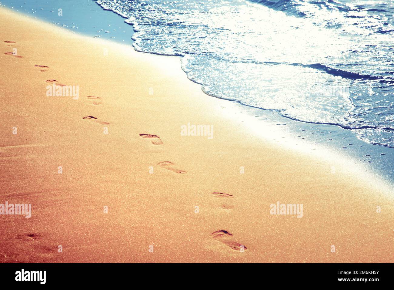 Walking on the beach, leaving footprints in the sand Stock Photo - Alamy