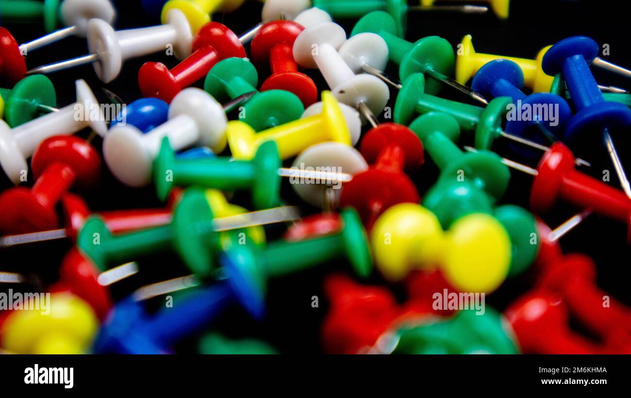 colorful thumbtacks on black background Stock Photo - Alamy