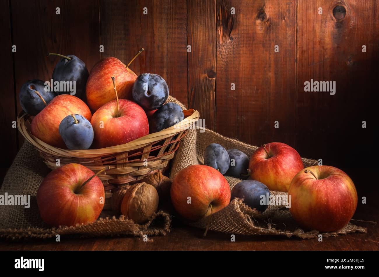 Apples and other fruits on a dark wooden background in a rustic style ...