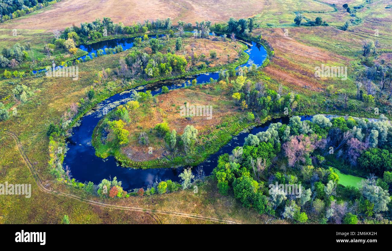 The channel and bends of the river, on a marshy meadow. Orange dry ...
