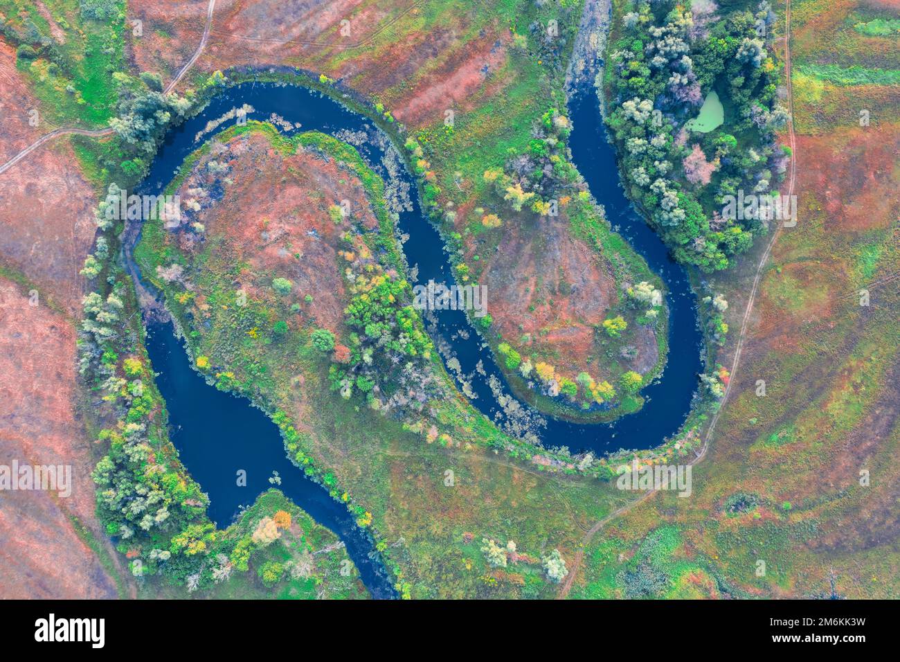 The channel and bends of the river, on a marshy meadow. Orange dry ...