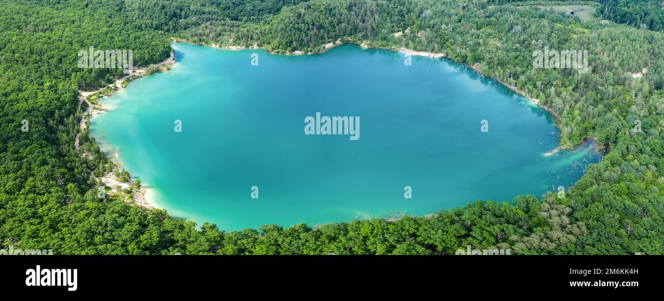 Clean lake with blue water in a pine forest. Drone view. A wonderful ...