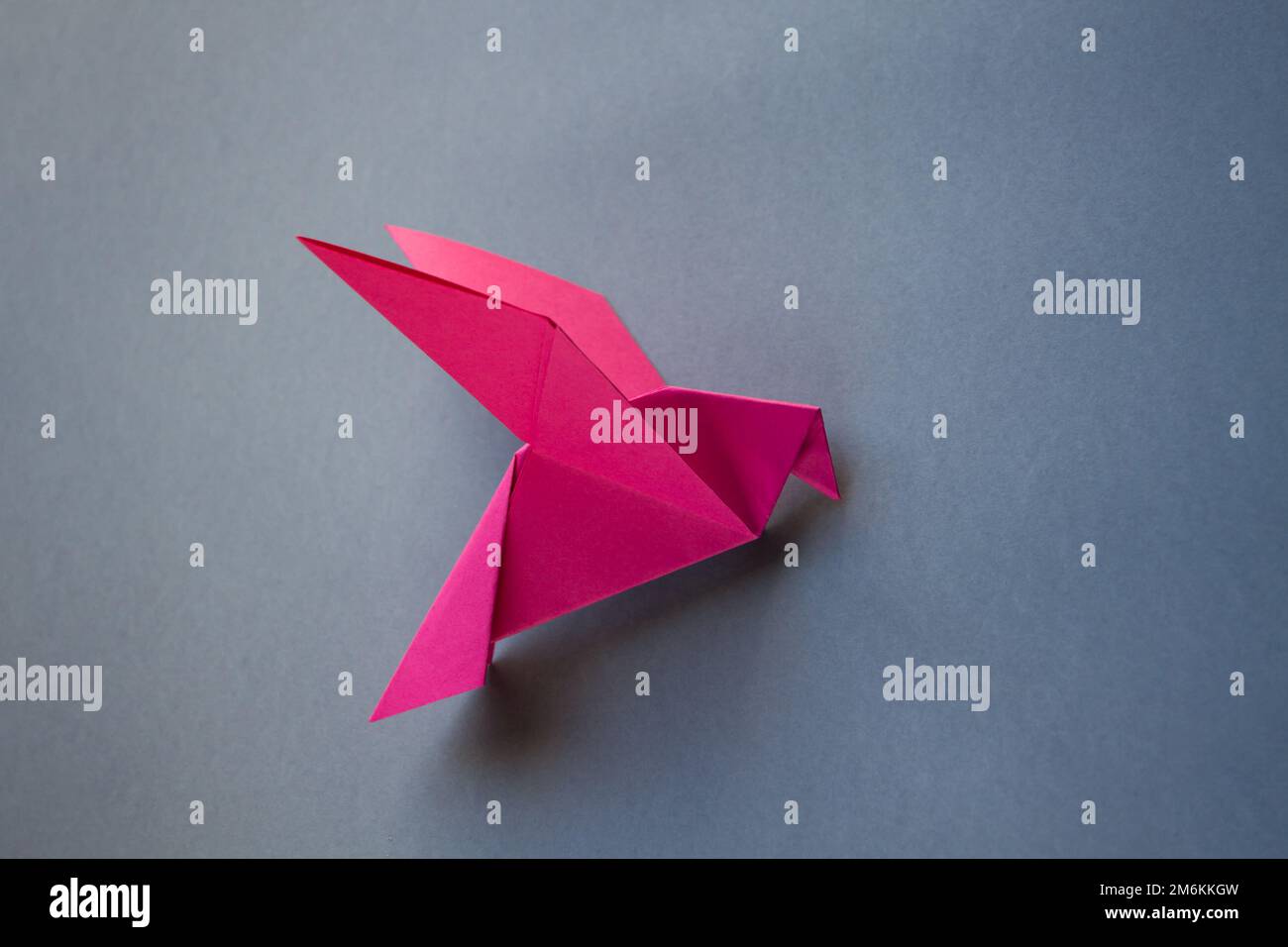 Pink paper dove origami isolated on a grey background Stock Photo - Alamy