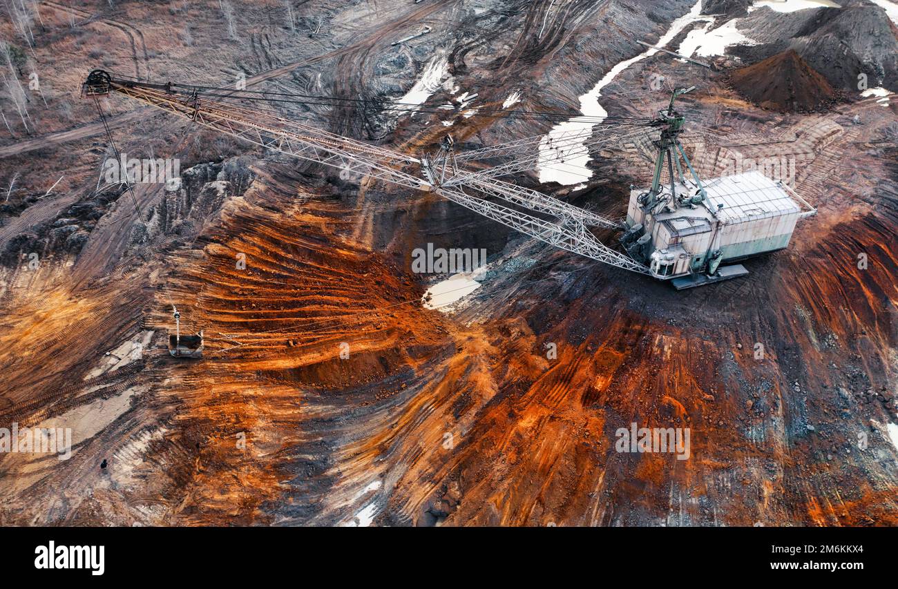 A large walking excavator works in a quarry for the extraction of rare ...