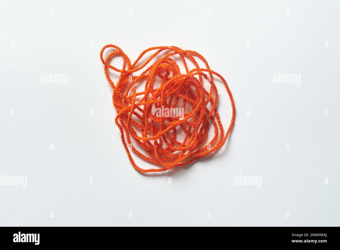 Red tangled thread on white Stock Photo - Alamy