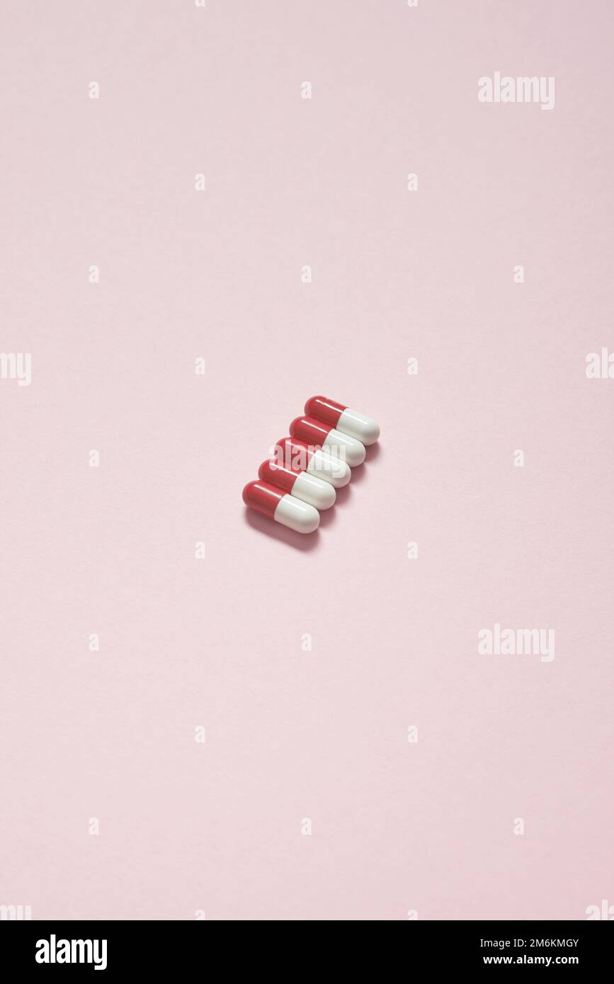 Pharmaceutical tablets over pink background Stock Photo - Alamy