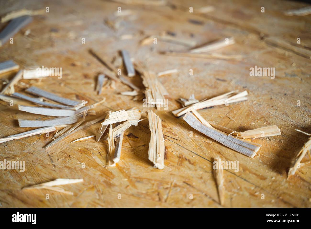 Wooden splinters and sawdust lie on the osb panel close-up. Waste of fitting wooden parts at a ...