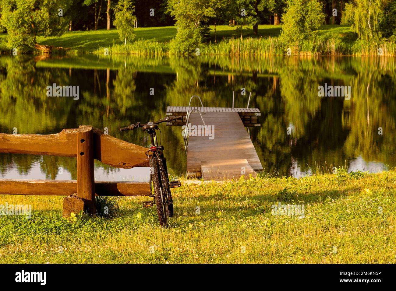 Modern sport bike leaning against wooden bench at lakeside Stock Photo ...