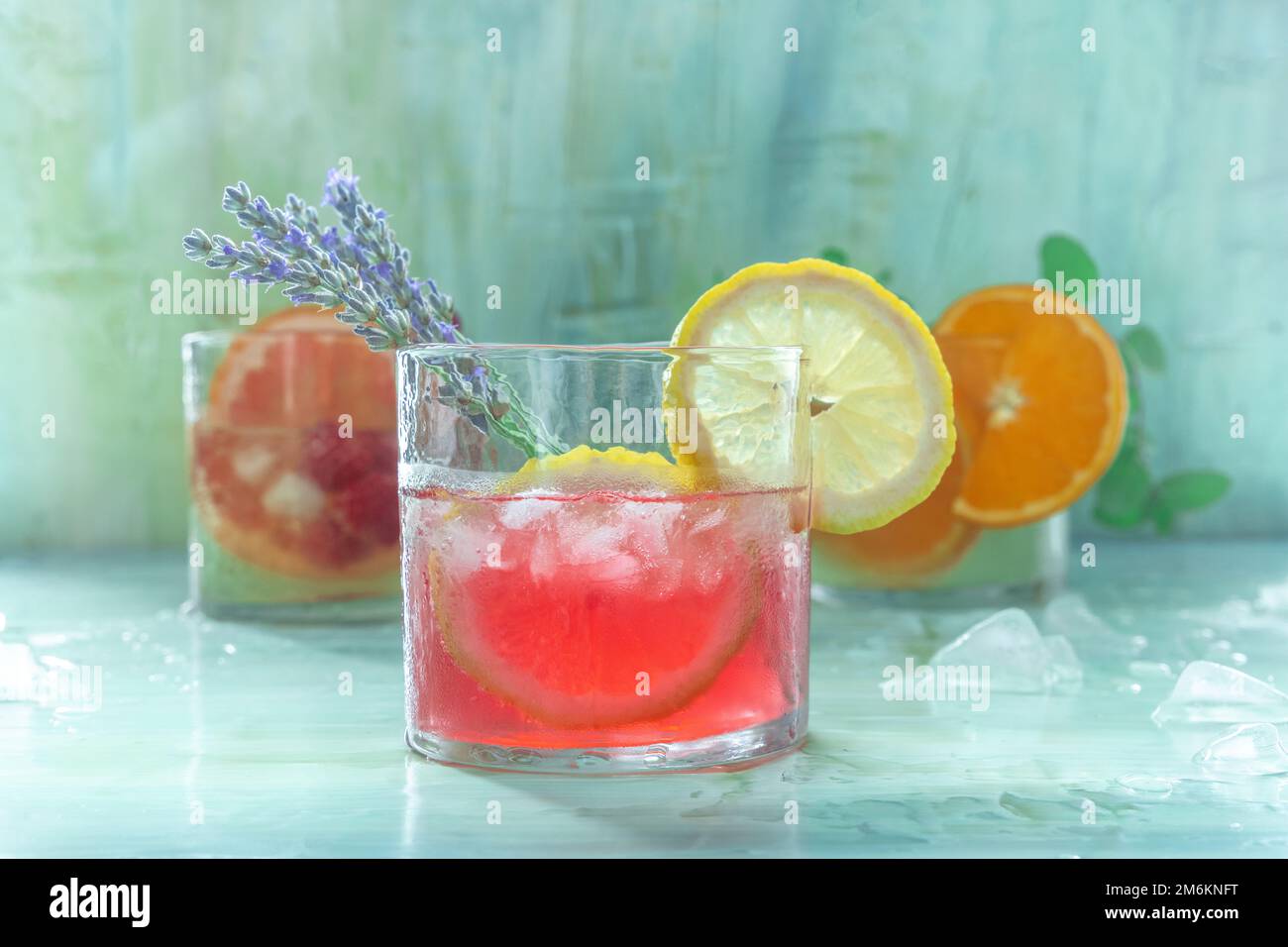 Summer cocktails or mocktails, cold drinks with ice, fruit and lavender ...