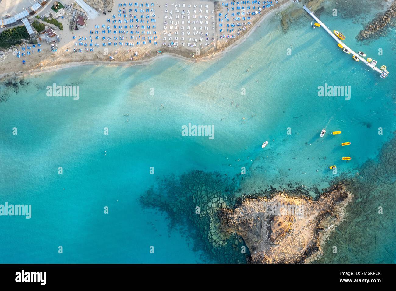 Beach umbrellas in a row at fig tree bay beach Protaras Cyprus. Summer ...